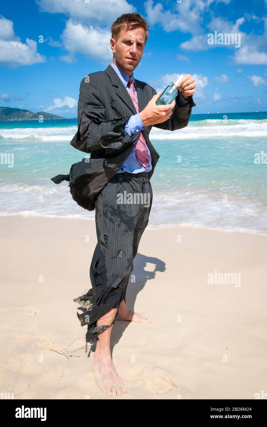 Castaway businessman standing on a tropical beach putting an SOS ...
