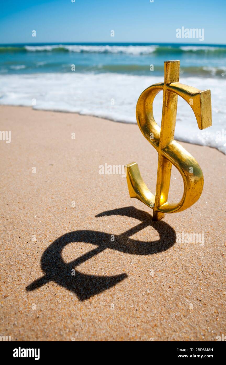 Big gold dollar sign casting a shadow on the shore of a sunny beach ...