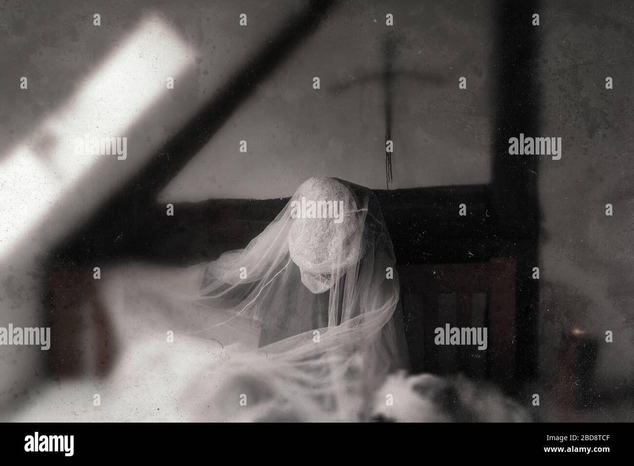 A ghost like figure, sitting on a bed in a corner of an old timber ...