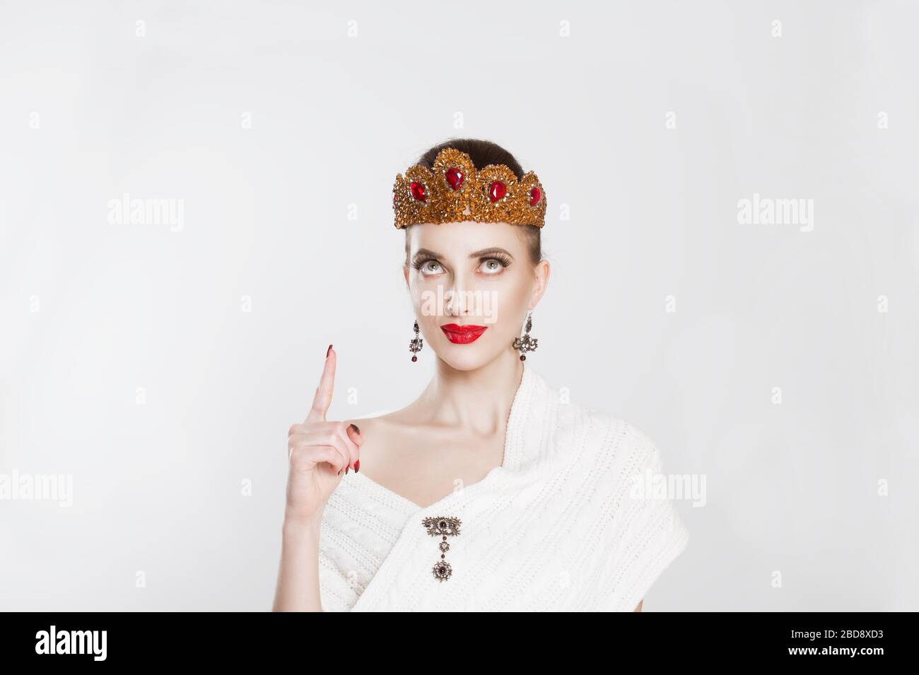 Look up here. Pretty cheerful woman gesturing with index finger and ...