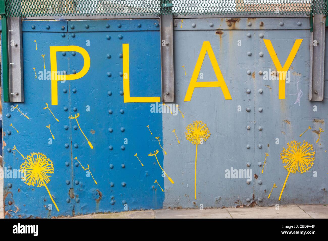 Word PLAY written in yellow on the side of an iron bridge painted blue ...