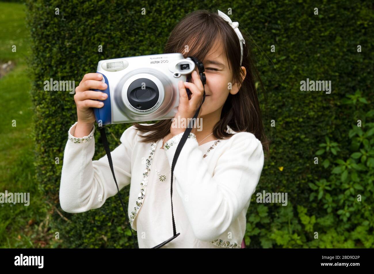 Young girl taking instant photos holding a large camera Stock Photo - Alamy