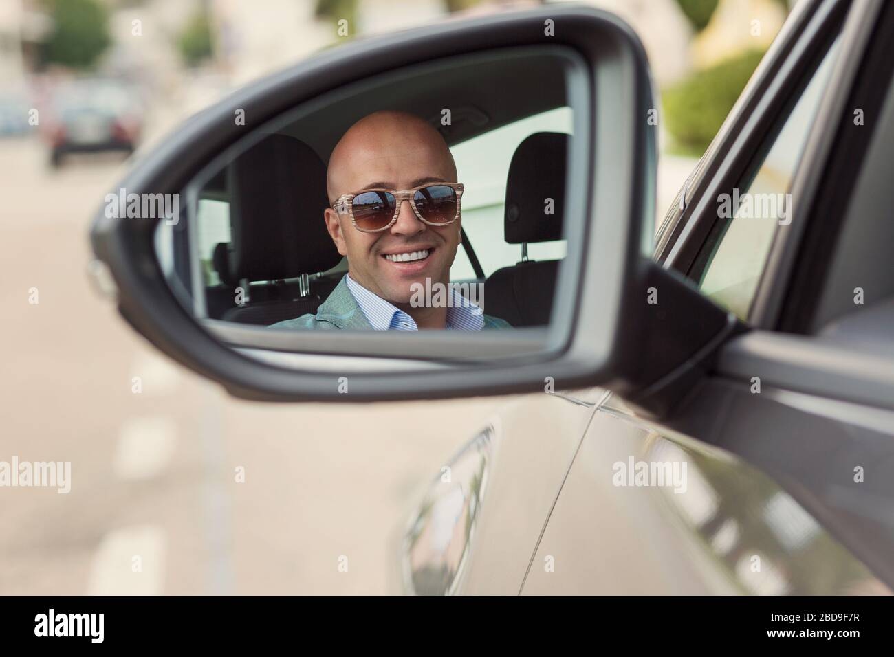 Handsome Caucasian business man looking at you camera through rear view ...