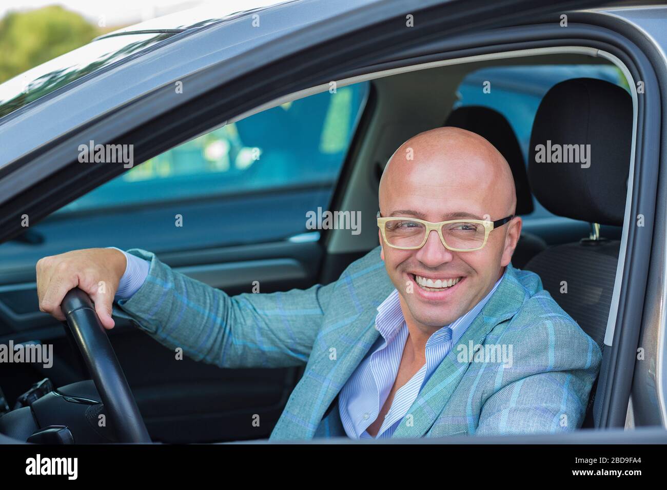 Handsome man smile on face sitting in his car, hands on wheel Stock ...