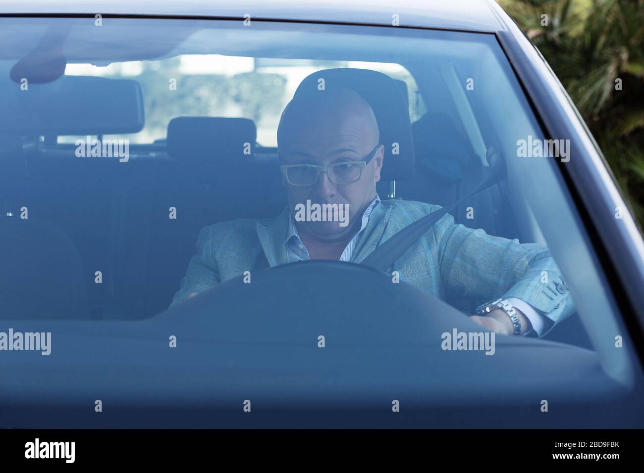 Shocked scared anxious funny looking young driver in the car. Human ...