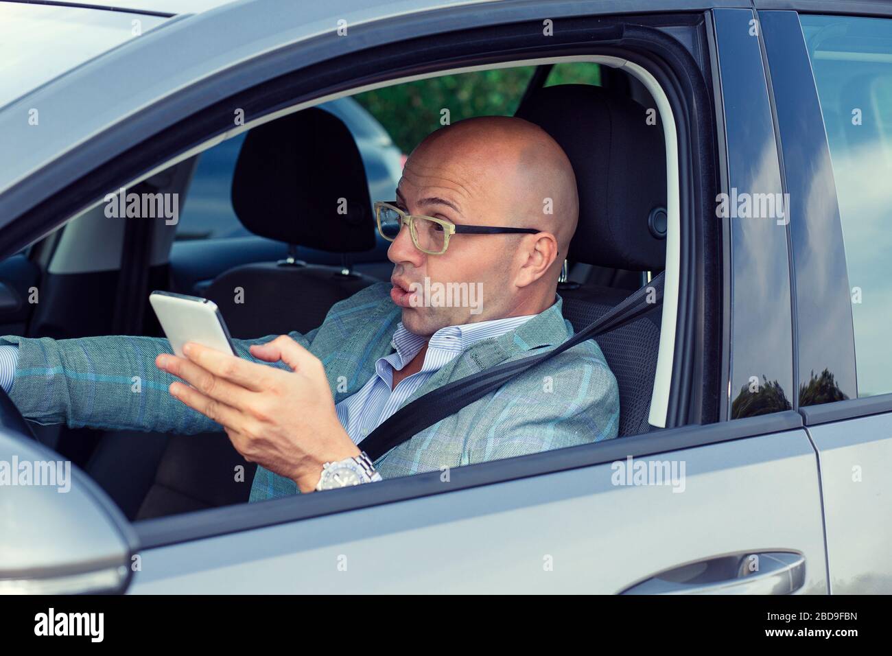 scared funny looking young man driver in the car about to make an ...