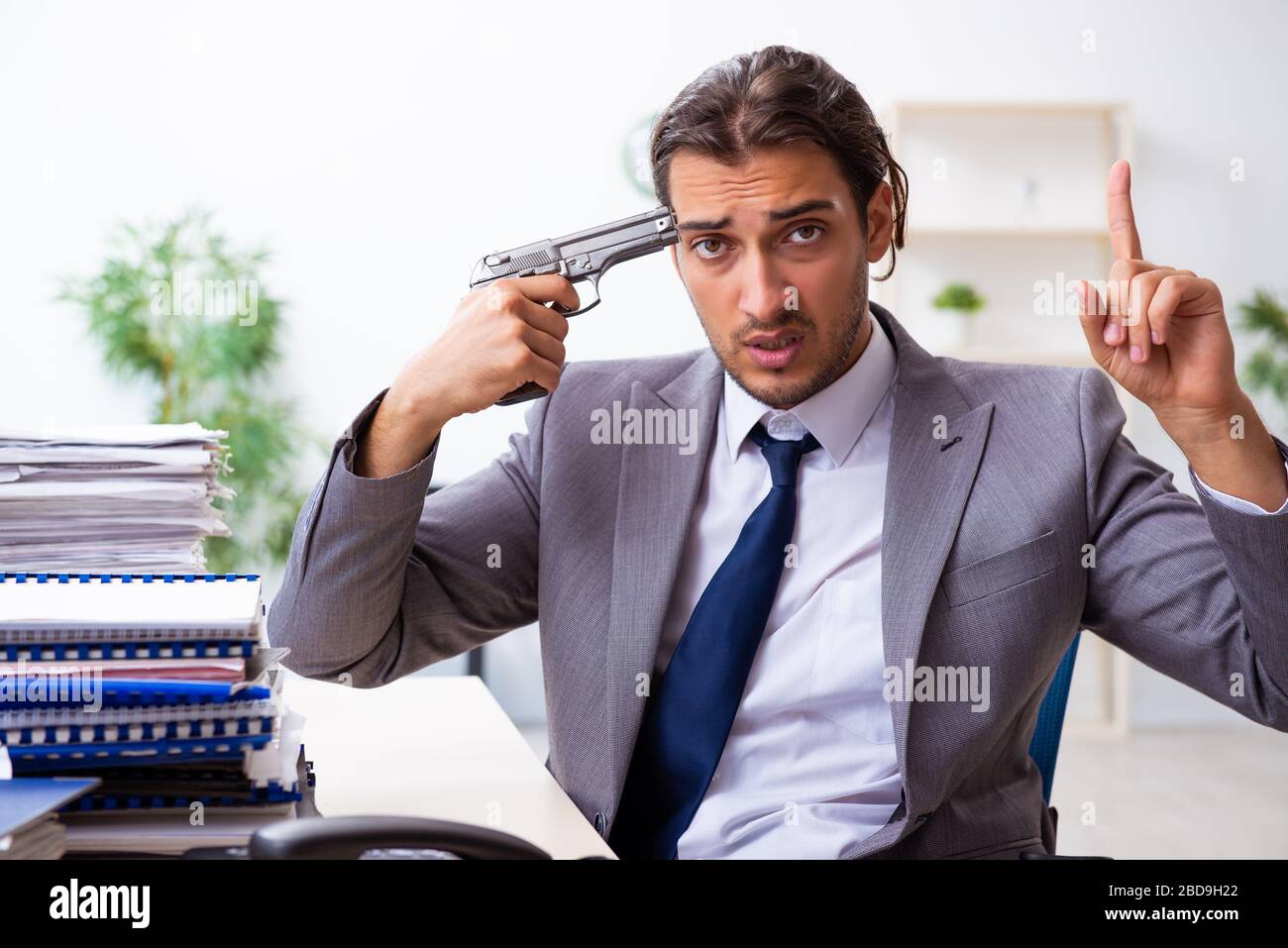 Young employee unhappy with excessive work Stock Photo - Alamy