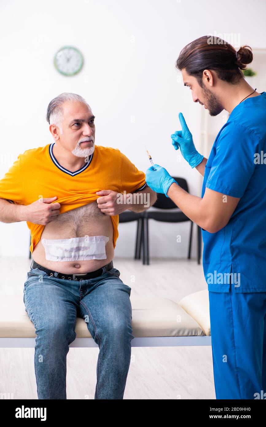 Old man visiting male doctor Stock Photo - Alamy