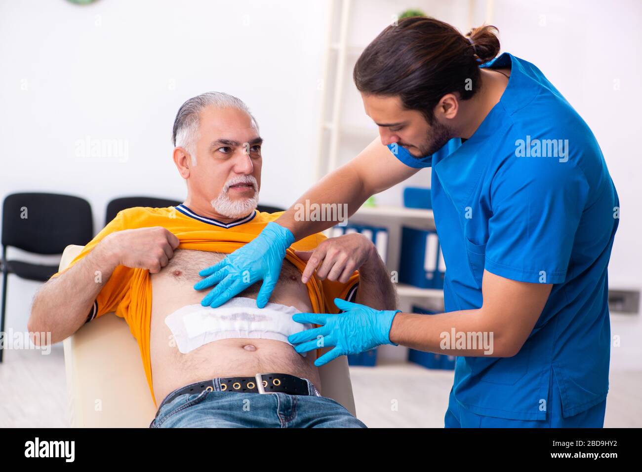 Old man visiting male doctor Stock Photo - Alamy
