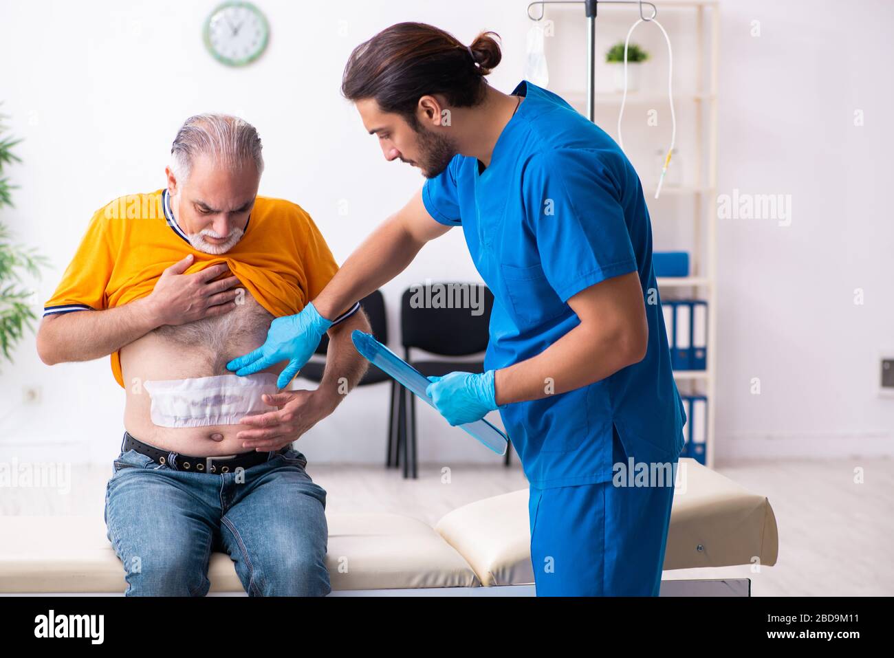 Old man visiting male doctor Stock Photo - Alamy