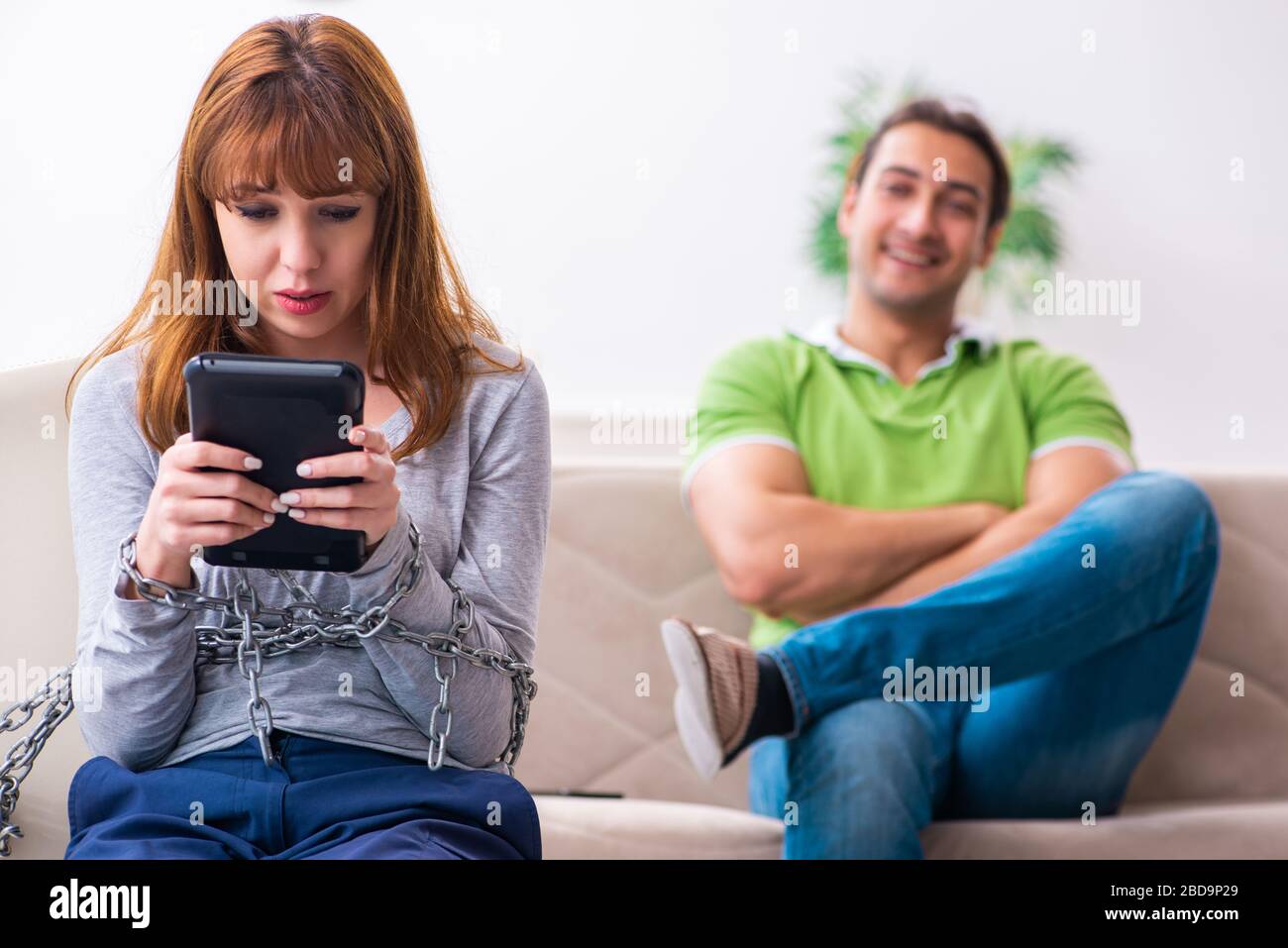 Young couple in gadget dependency disorder Stock Photo - Alamy