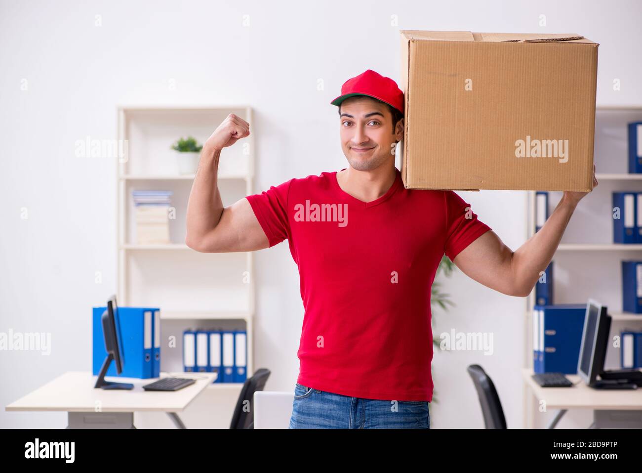 Young courier delivering postbox to the office Stock Photo - Alamy