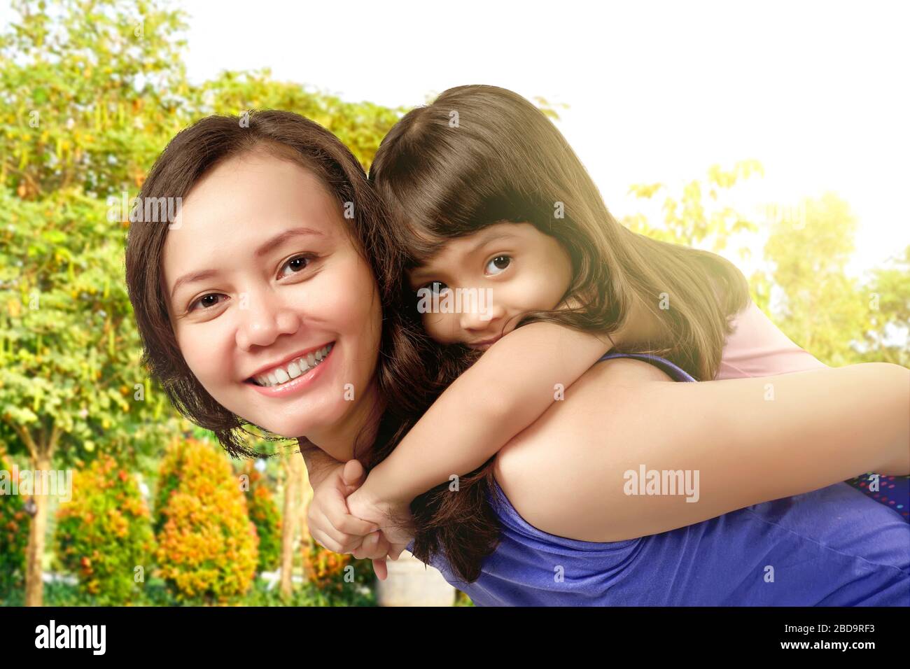 Asian mother carrying her little girl on her back. Mothers day concept ... Asian mother carrying her little girl on her back. Mothers day concept ...