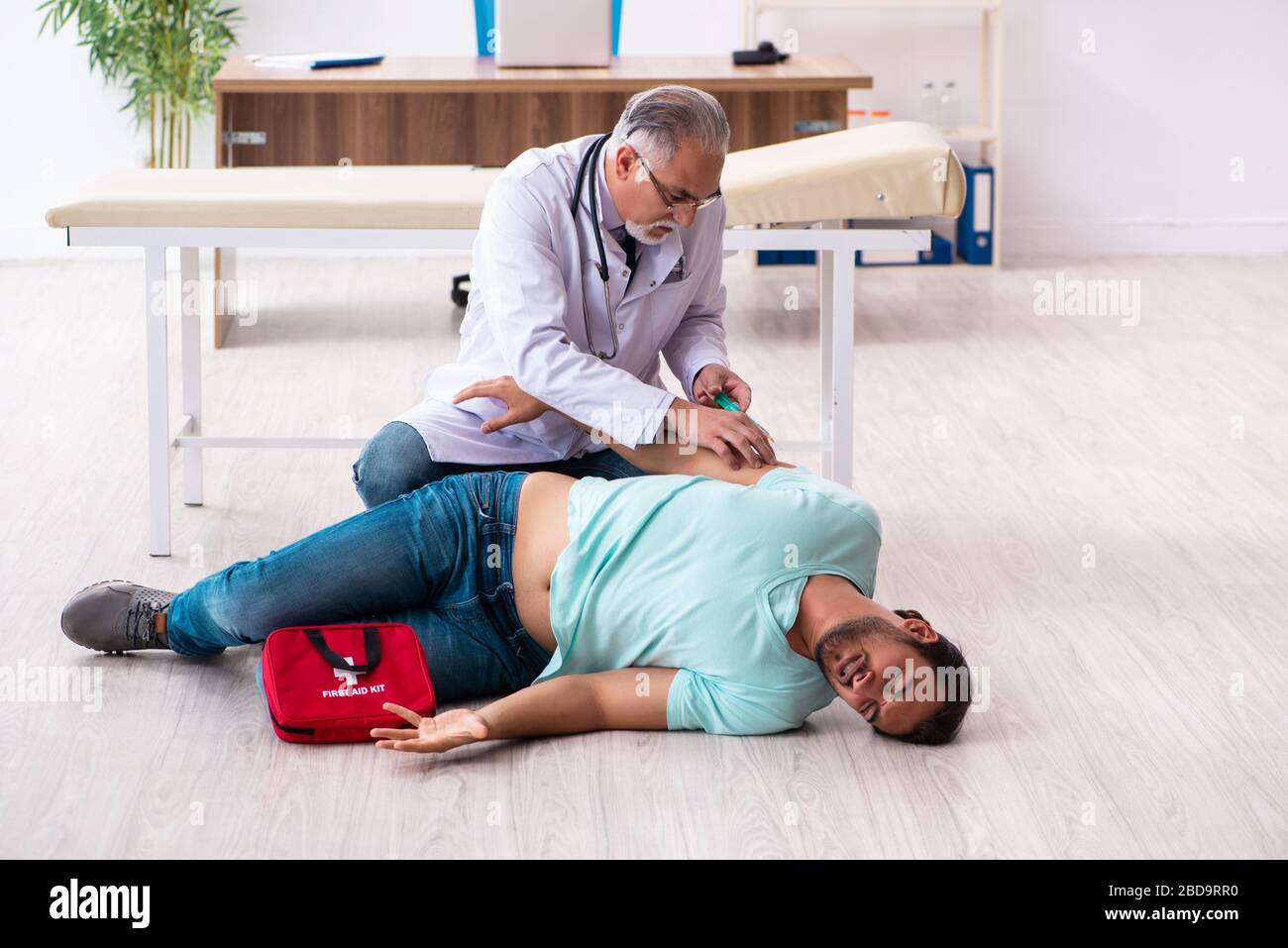 Experienced doctor and male patient in first aid concept Stock Photo ...