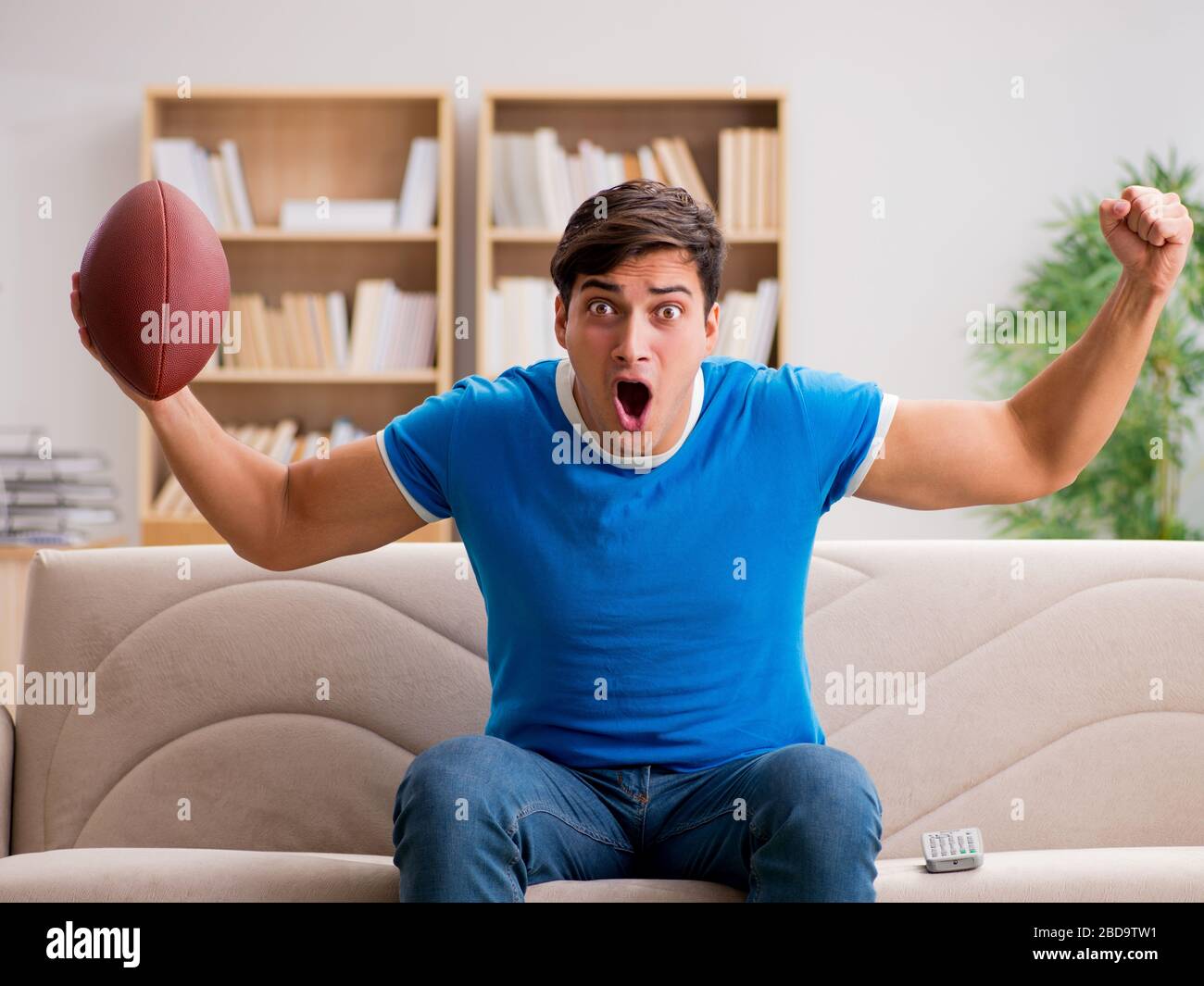 The man watching football at home sitting in couch Stock Photo - Alamy