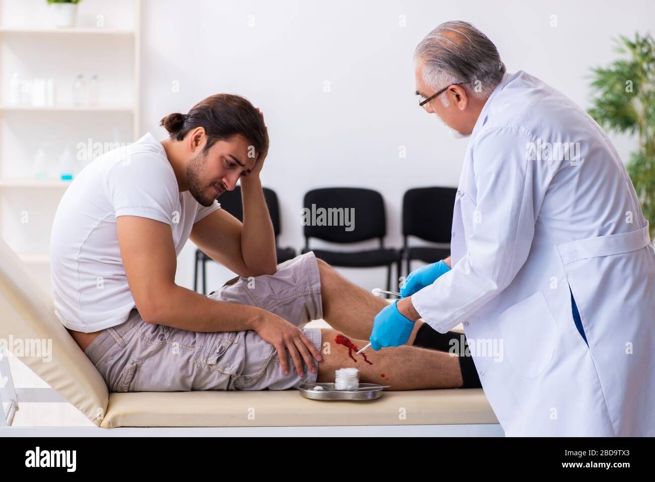 Leg injured man visiting doctor in first aid concept Stock Photo - Alamy