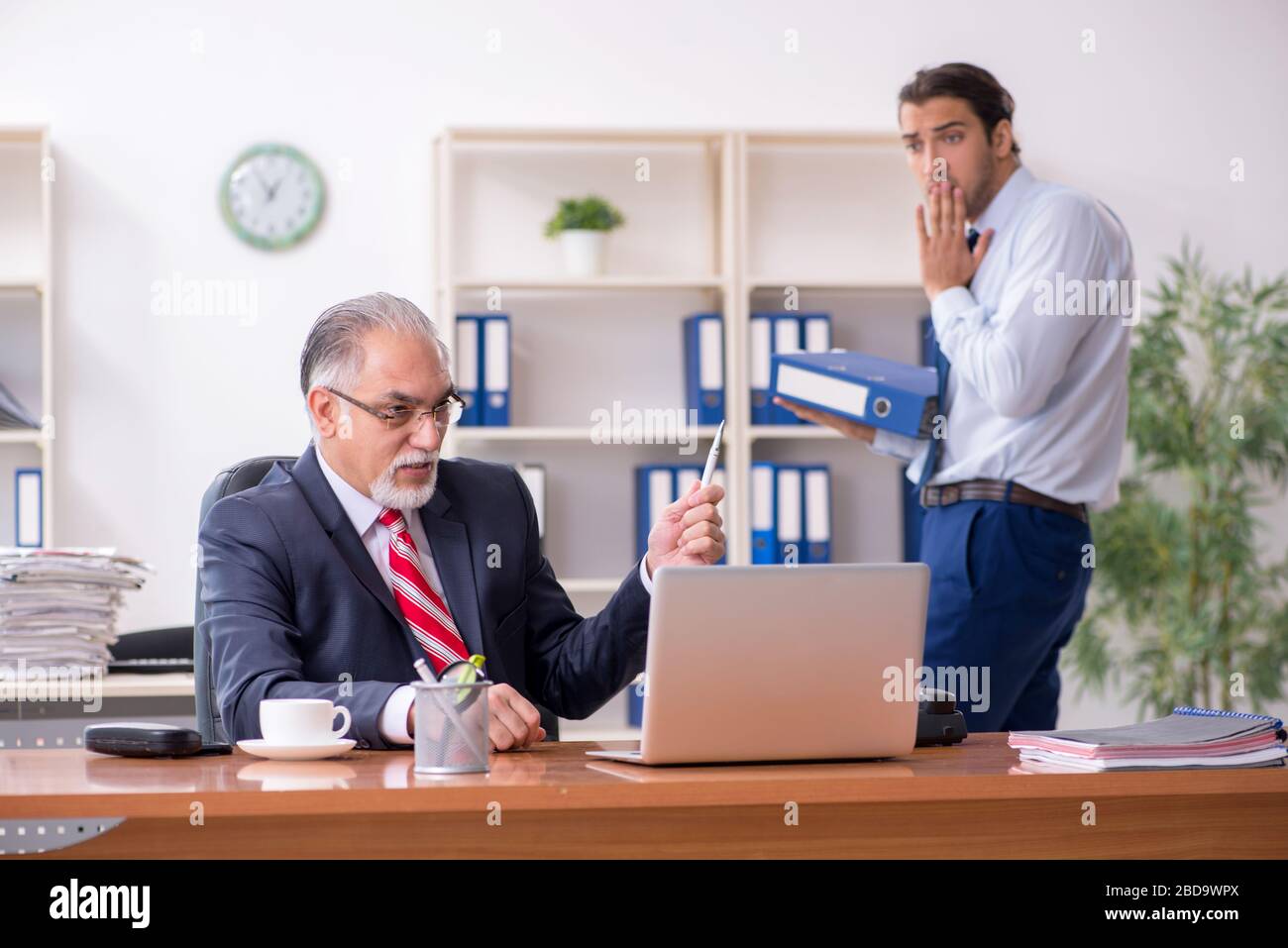 Old boss and young employee in the office Stock Photo - Alamy