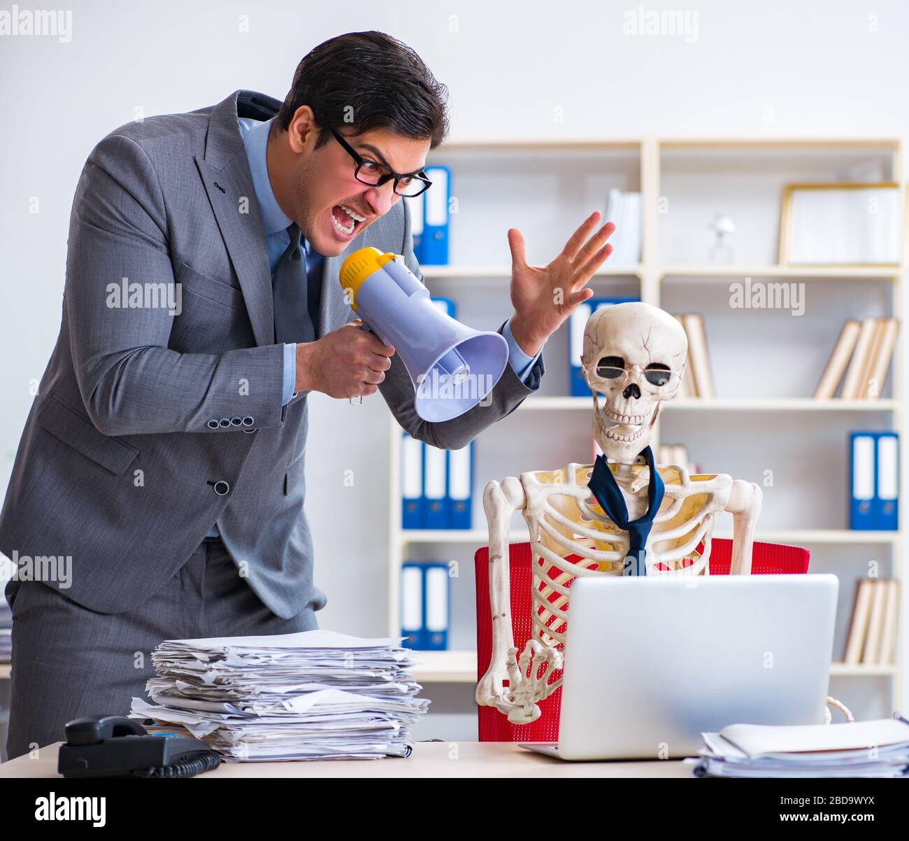 The angry boss yelling at his skeleton employee Stock Photo - Alamy