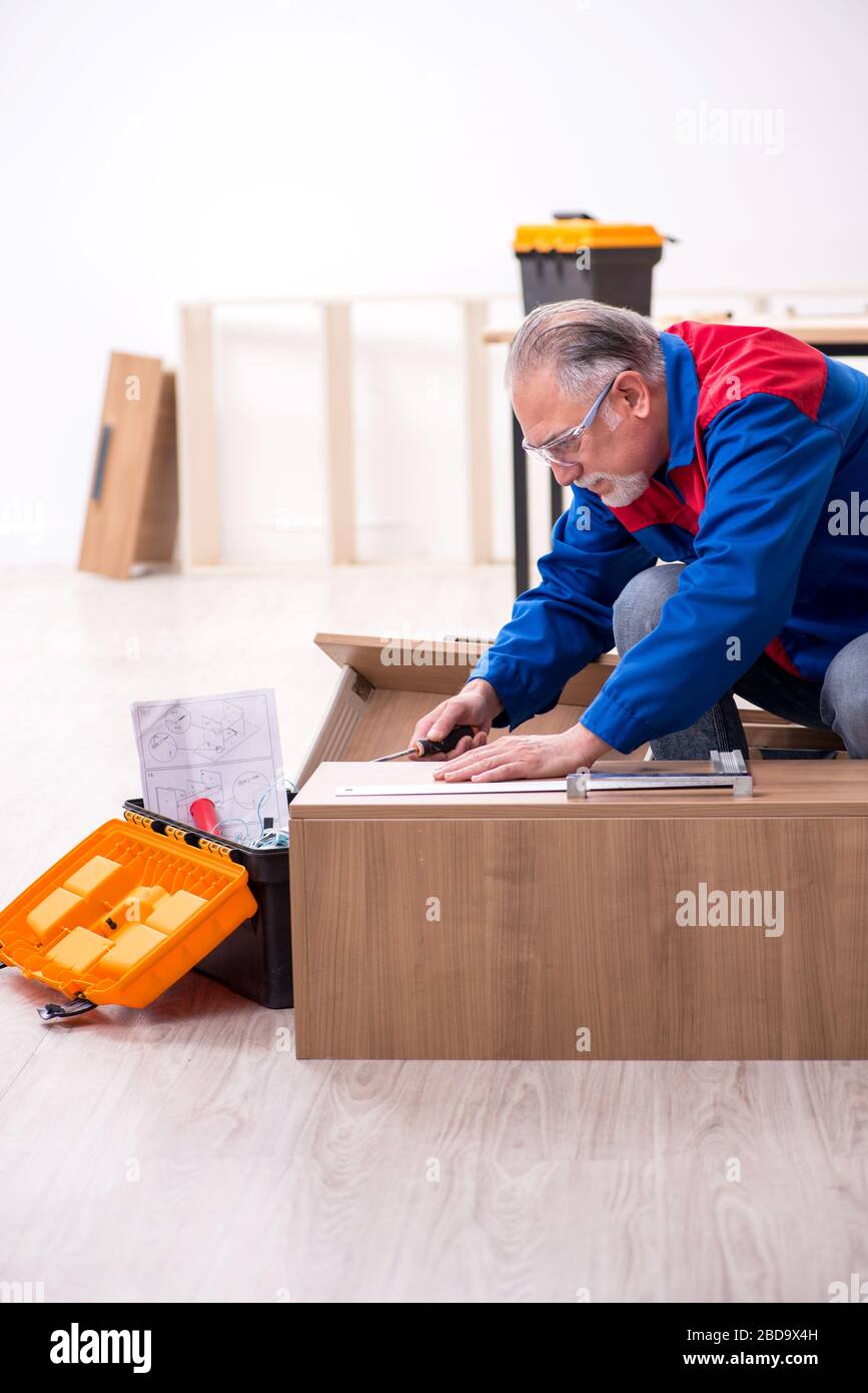 Old carpenter working indoors on furniture Stock Photo - Alamy