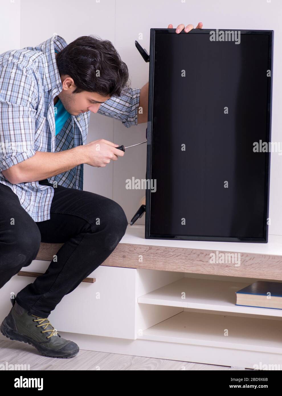 The man repairing broken tv at home Stock Photo - Alamy