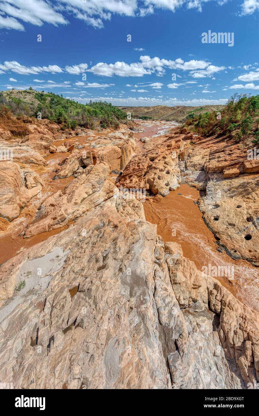 rocky river bed Betsiboka river after heavy rain, red yellow water ...