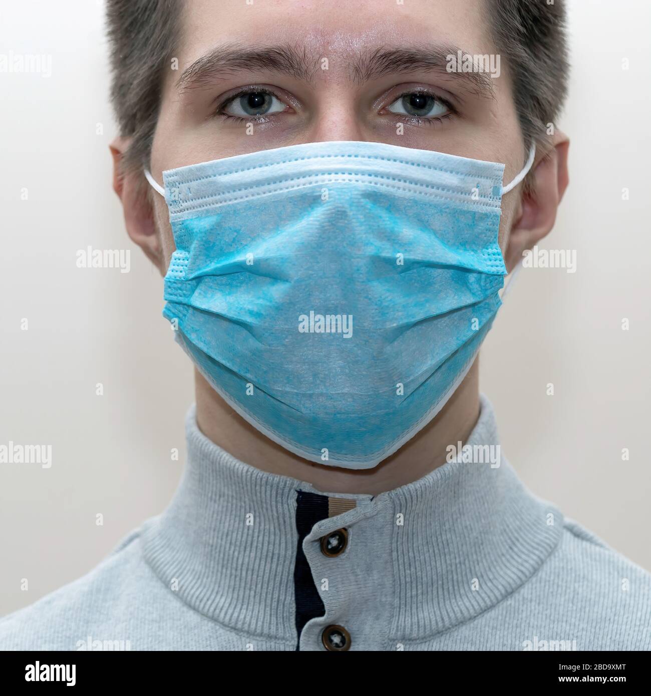 Young man in a medical mask smiles, portrait, close up, health care ...