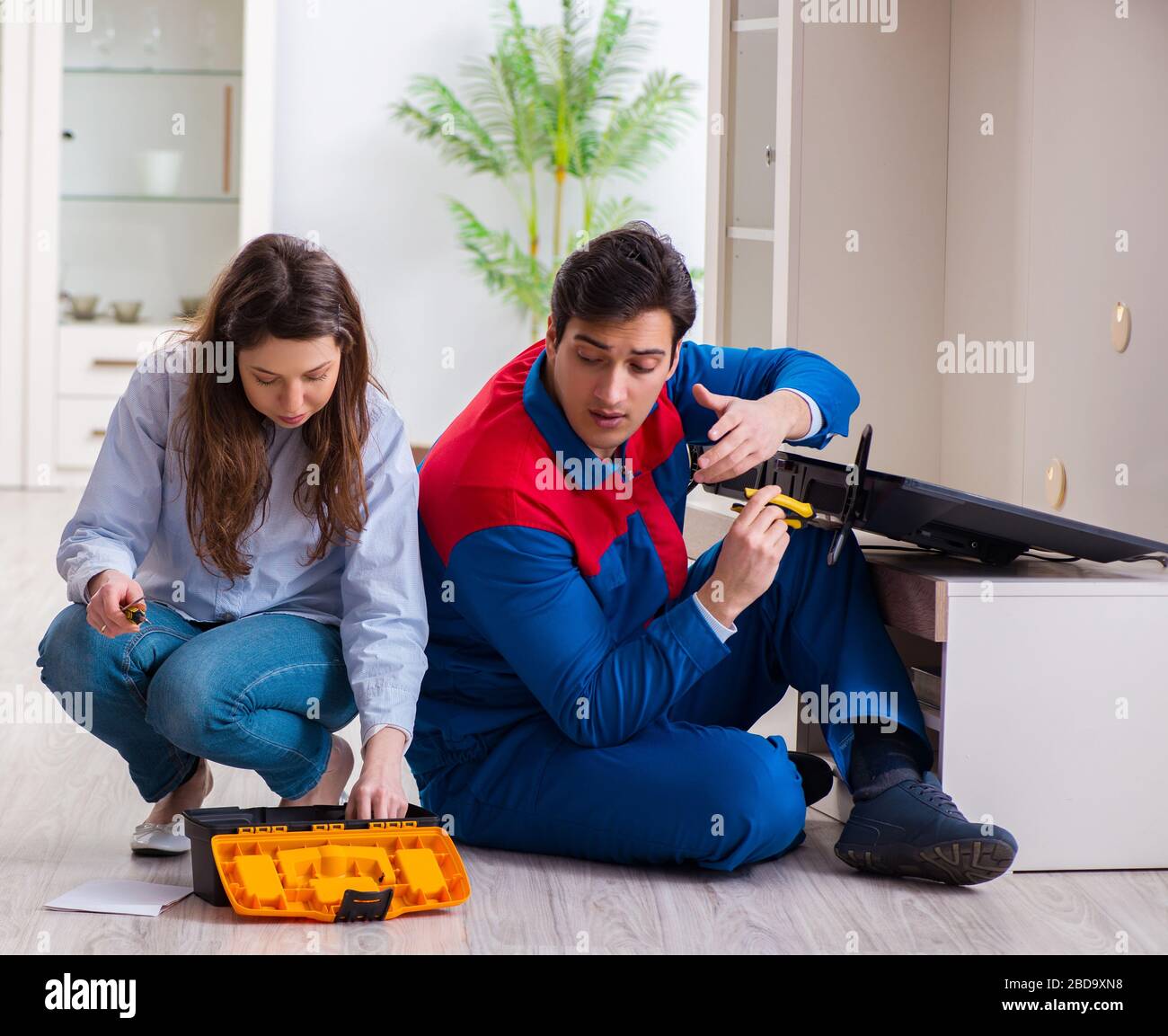 The repairman repairing tv at home Stock Photo - Alamy