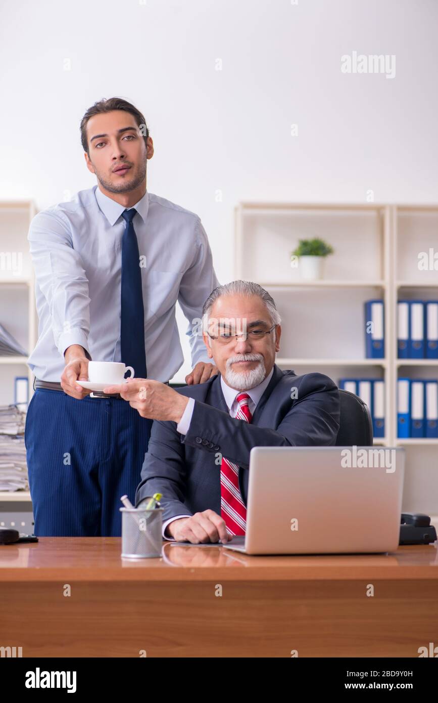 Old boss and young employee in the office Stock Photo - Alamy