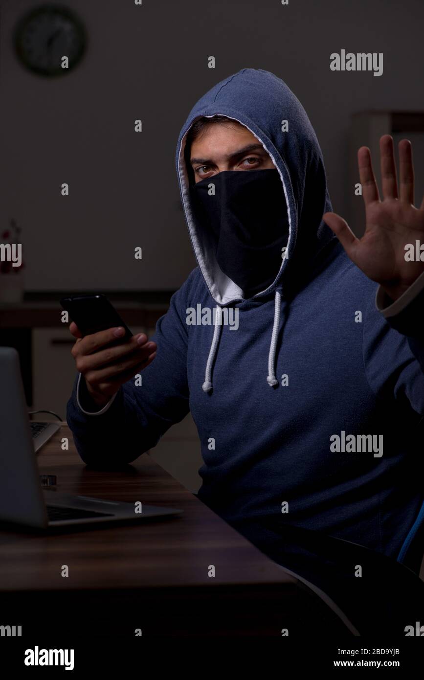 Male hacker hacking security firewall late in the office Stock Photo ...