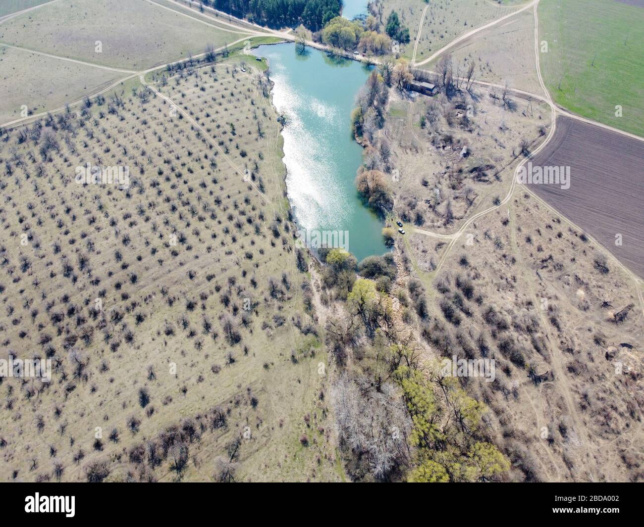 Spring garden and small lake from the altitude of quadcopter flight ...