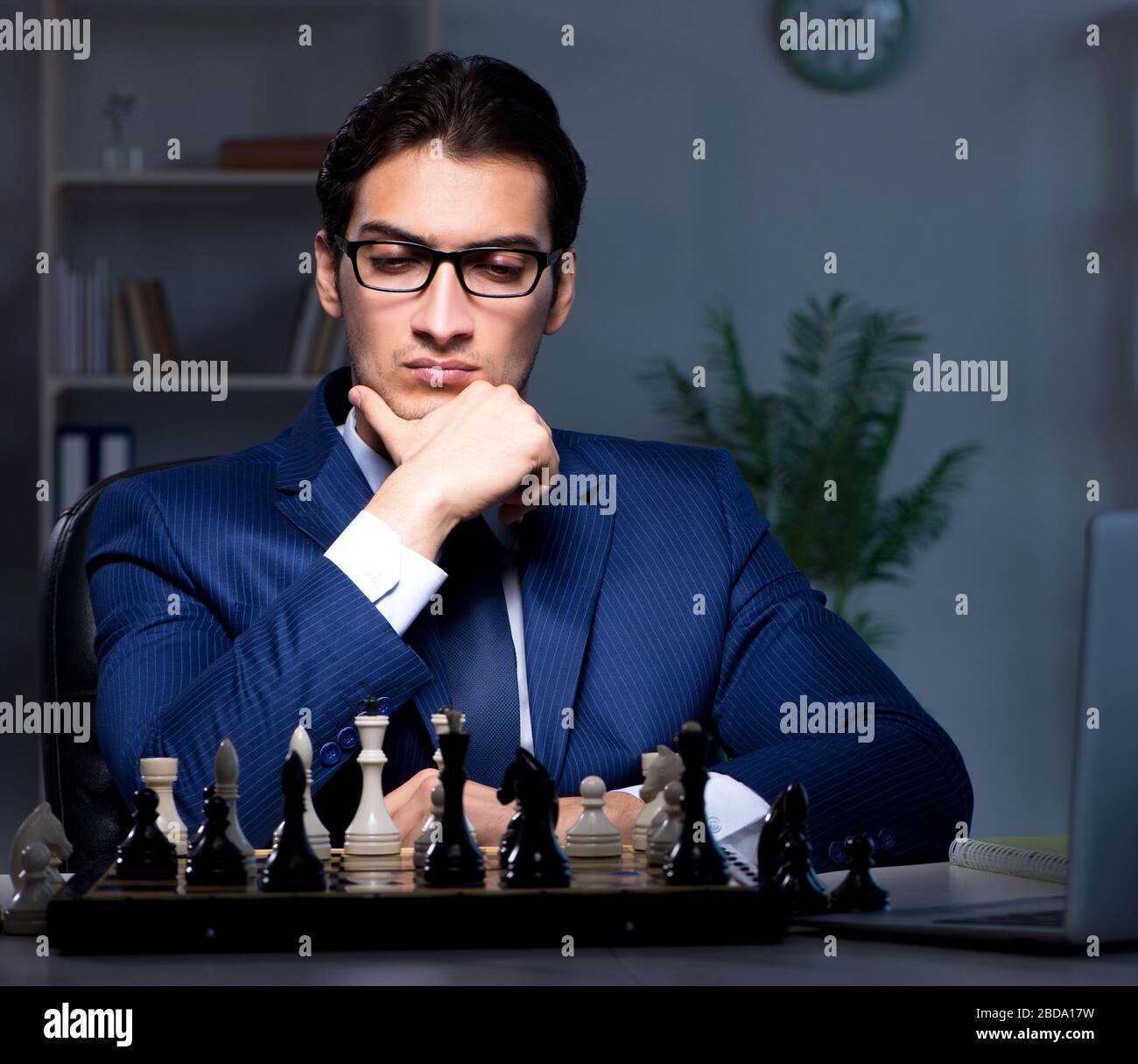 The businessman playing chess in strategy concept Stock Photo - Alamy