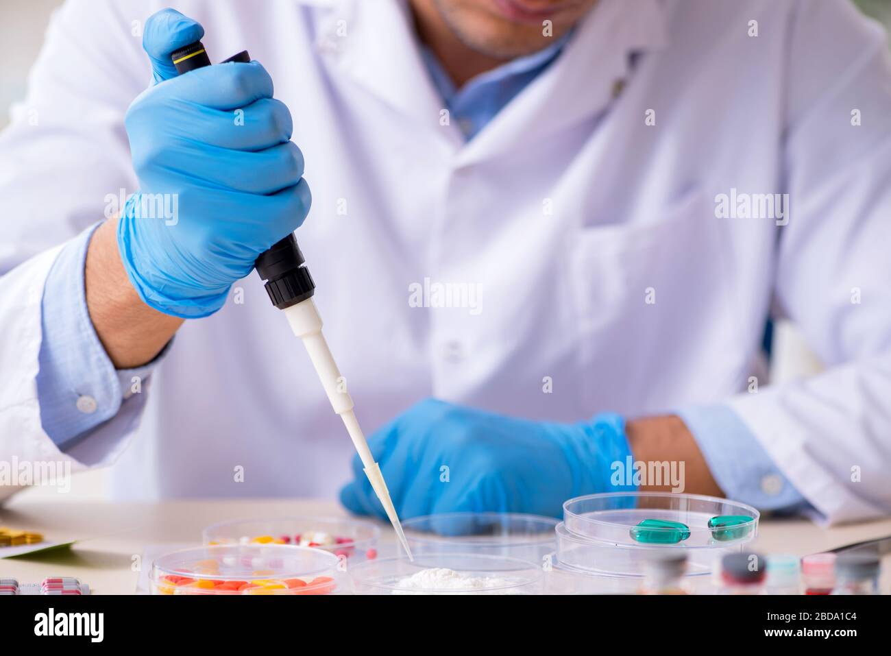 Young male lab assistant in the drug synthesis concept Stock Photo - Alamy