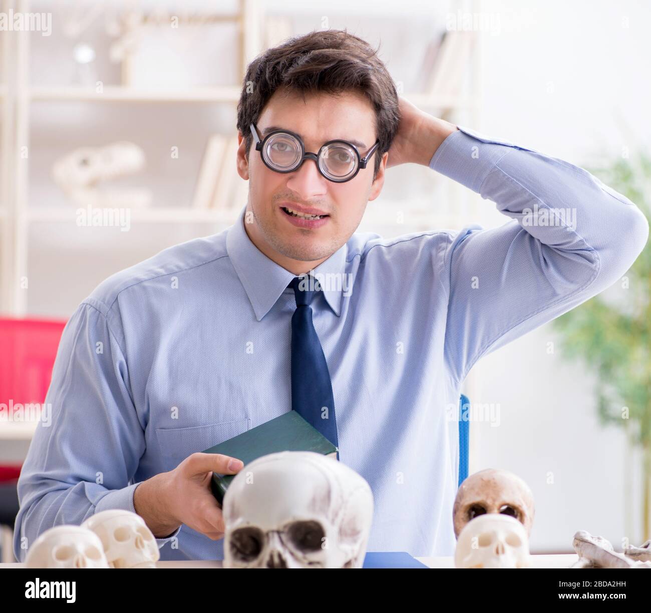 The funny crazy professor studying human skeleton Stock Photo - Alamy
