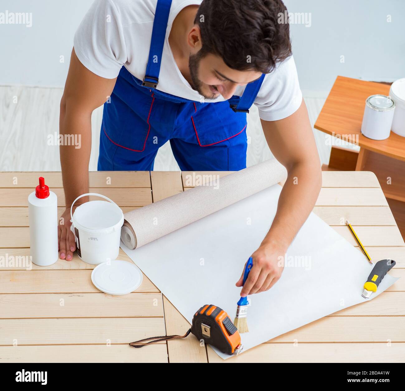 The worker working on wallpaper during refurbishment Stock Photo - Alamy