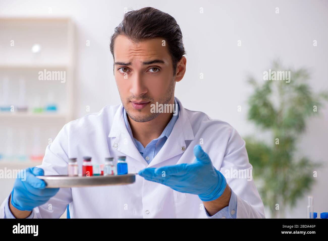 Young male lab assistant in the drug synthesis concept Stock Photo - Alamy