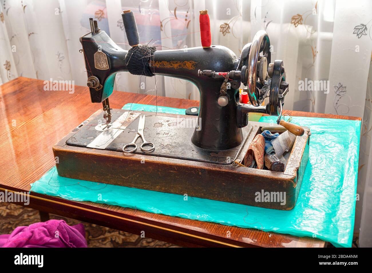 Vintage sewing machine and scissors on the table. Black and white photo ...