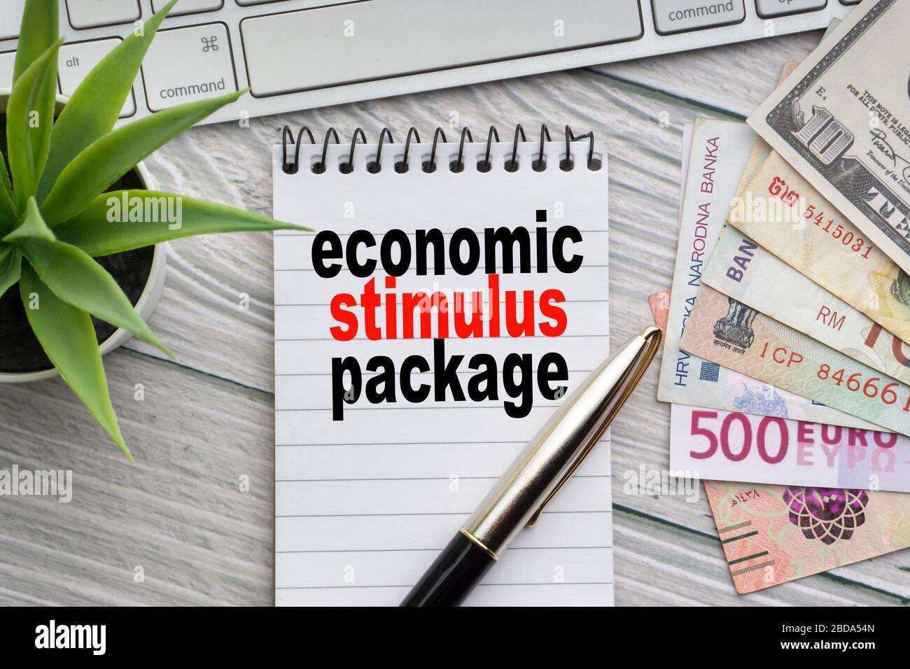 ECONOMIC STIMULUS PACKAGE text with notepad, keyboard, decorative vase ...