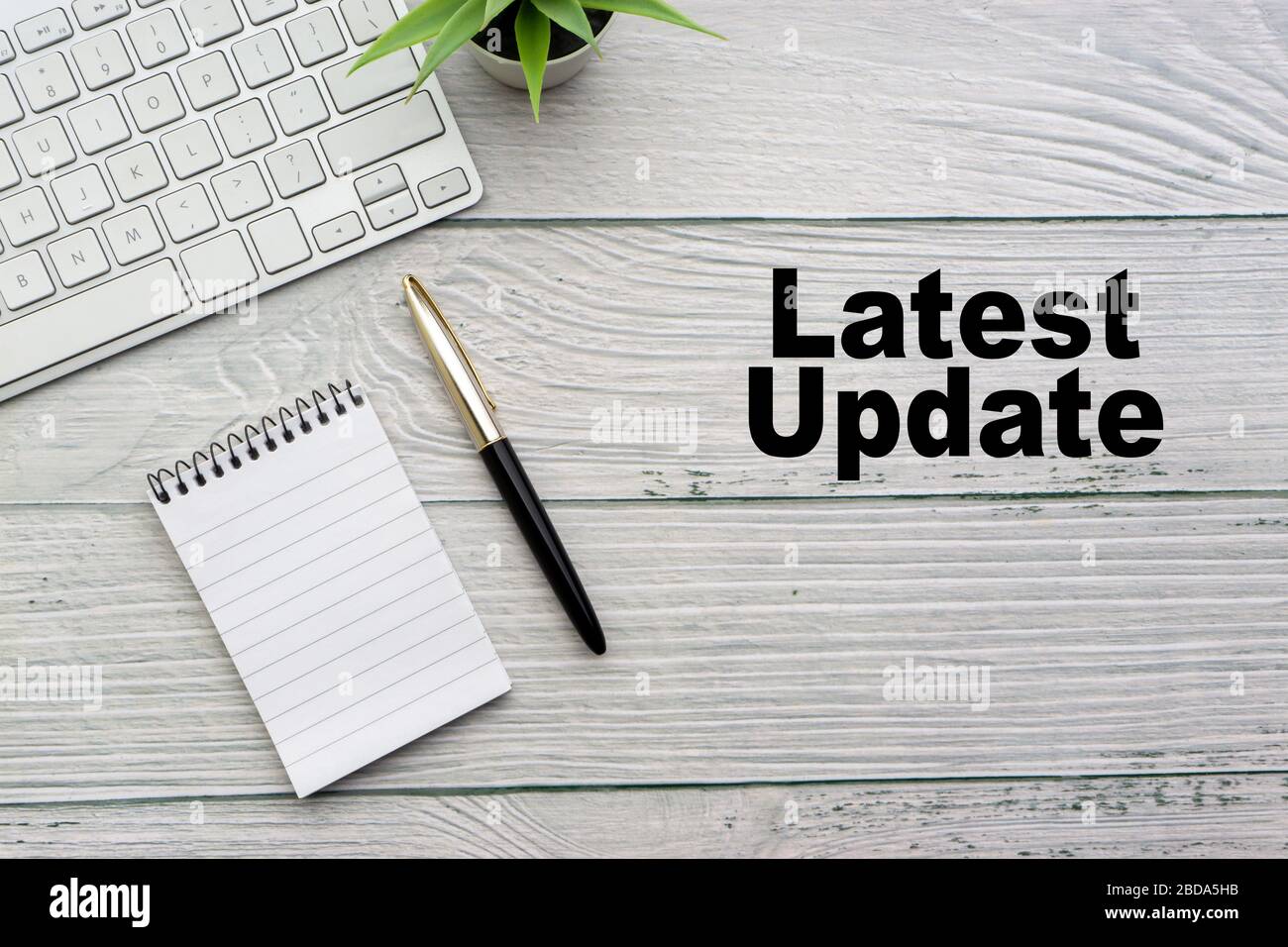 LATEST UPDATE text with notepad, keyboard, decorative vase and fountain ...