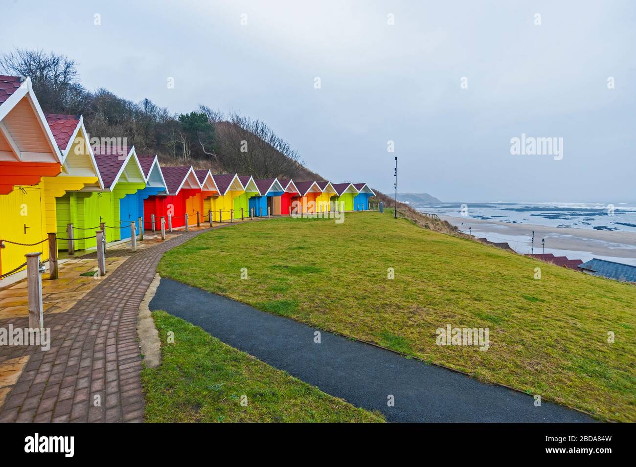 Row of brightly multicolored colorful wooden beach huts in seaside ...
