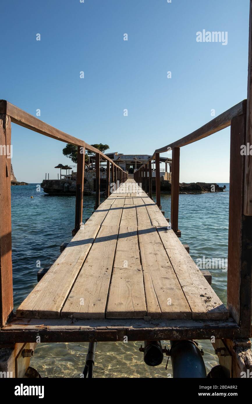 Wooden bridge leading across Sea to an island with an restaurant in ...