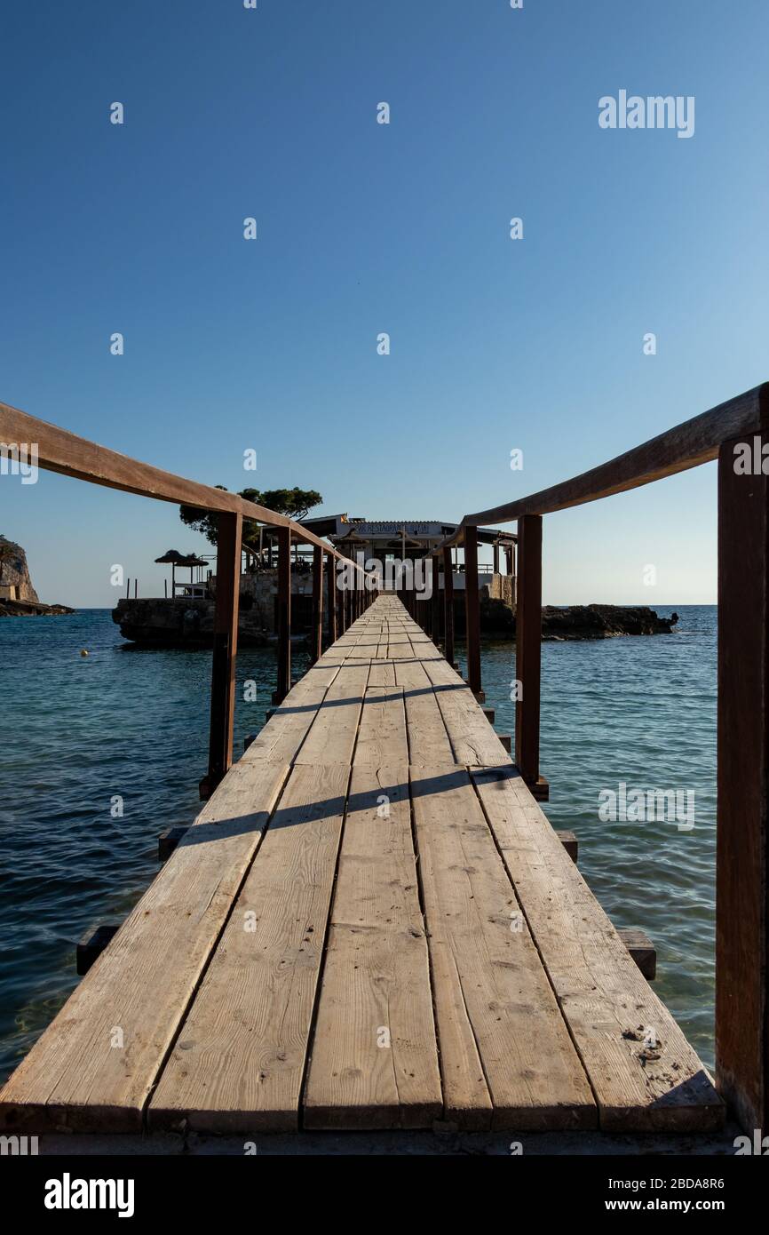 Wooden bridge leading across Sea to an island with an restaurant in ...