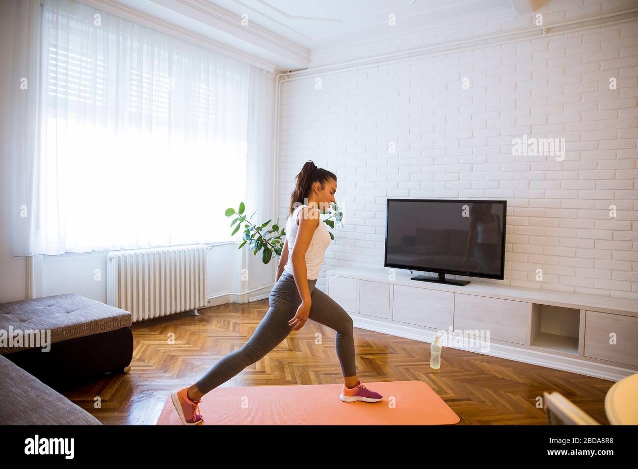Cute young attractive woman practicing exercises at home Stock Photo ...