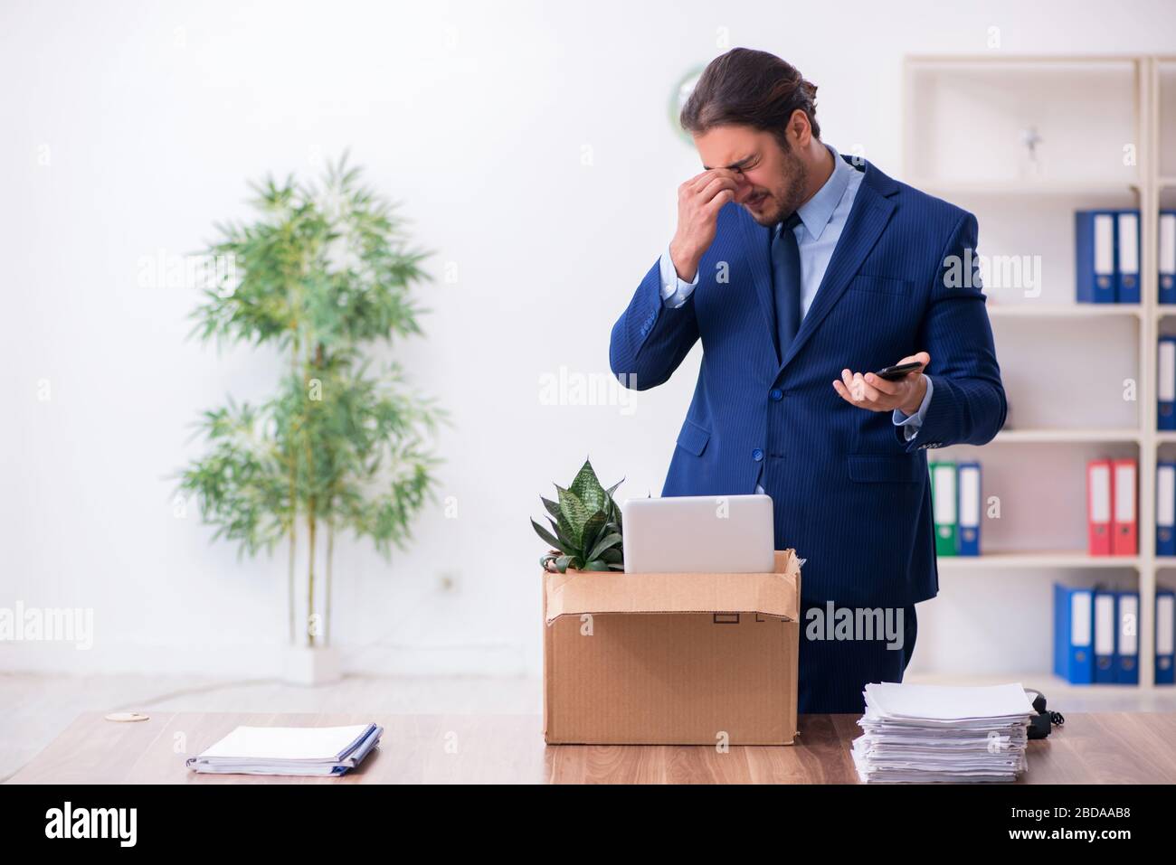 Young man being fired from his workplace Stock Photo - Alamy