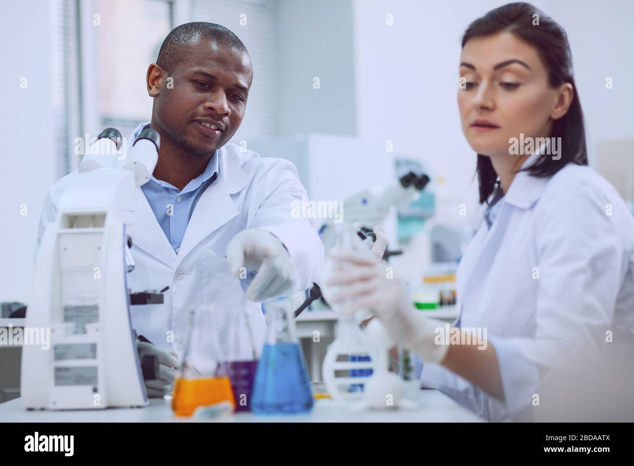 Inspired professional scientists carrying out a test Stock Photo - Alamy