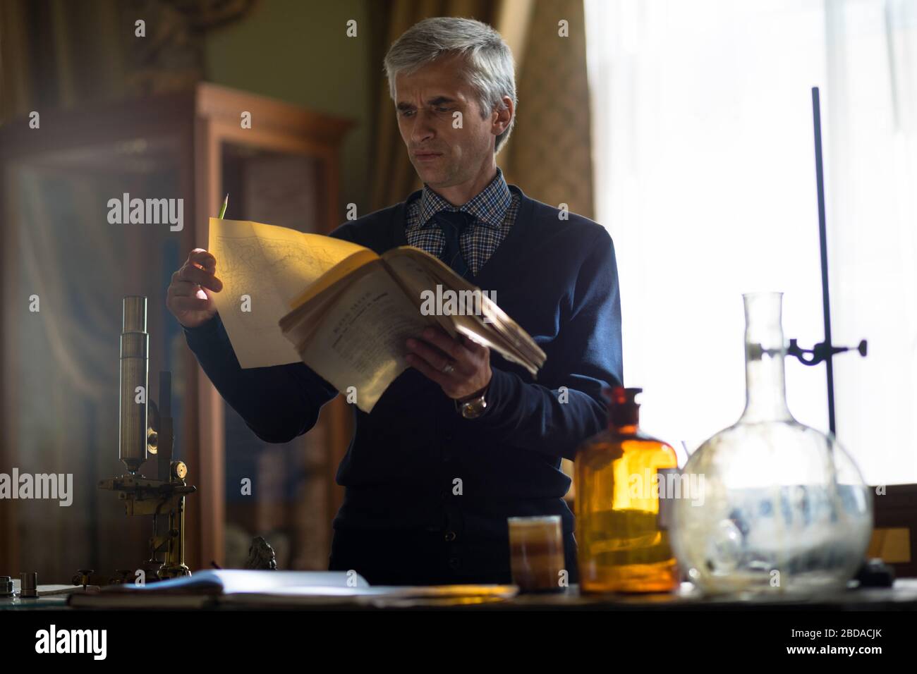 Scientist reading book in his laboratory Stock Photo - Alamy