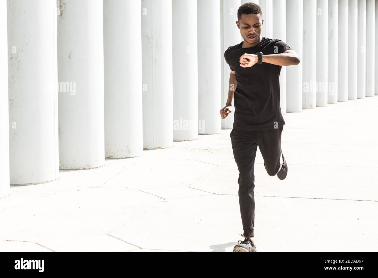 Athletic young afroamerican man running on the promenade. Black Male ...