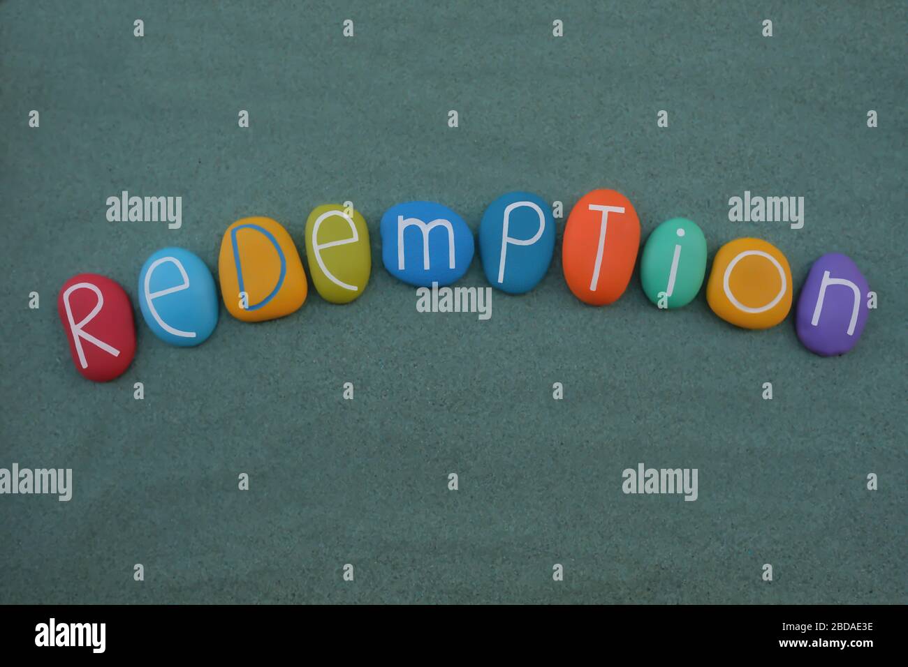 Redemption word composed with multi colored stone letters over green ...