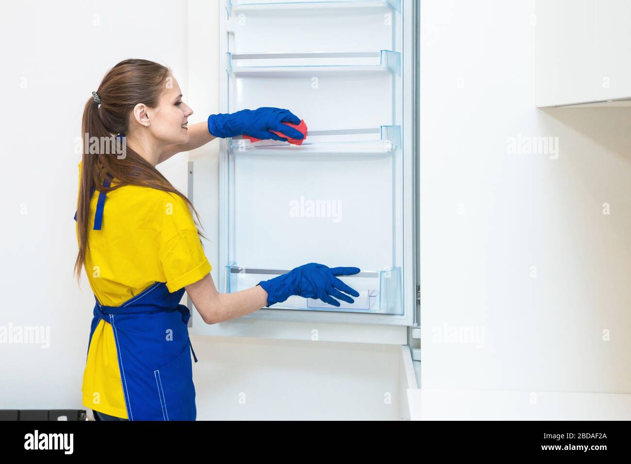 professional cleaning service. Two women in working uniform, in aprons ...