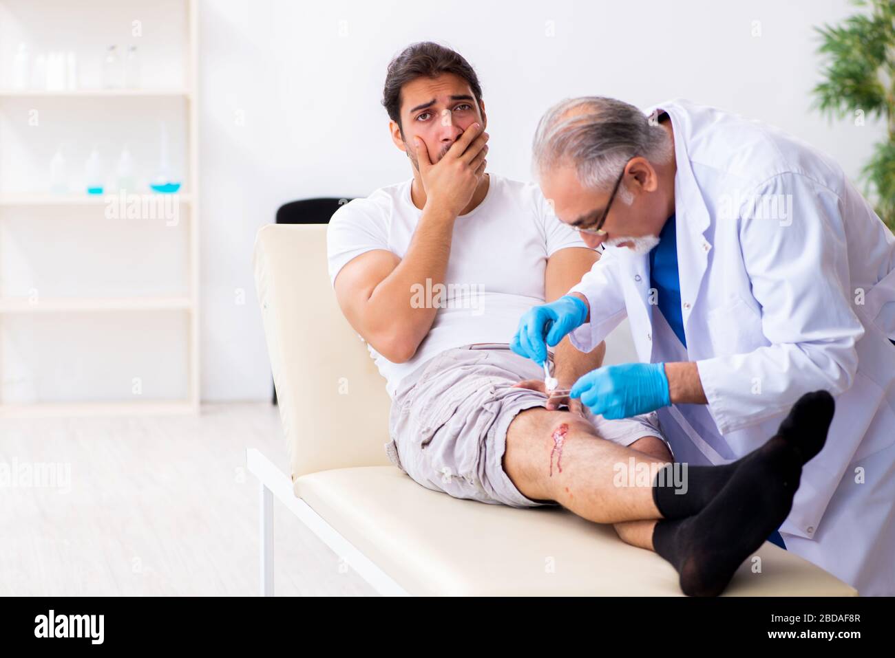 Leg injured man visiting doctor in first aid concept Stock Photo - Alamy