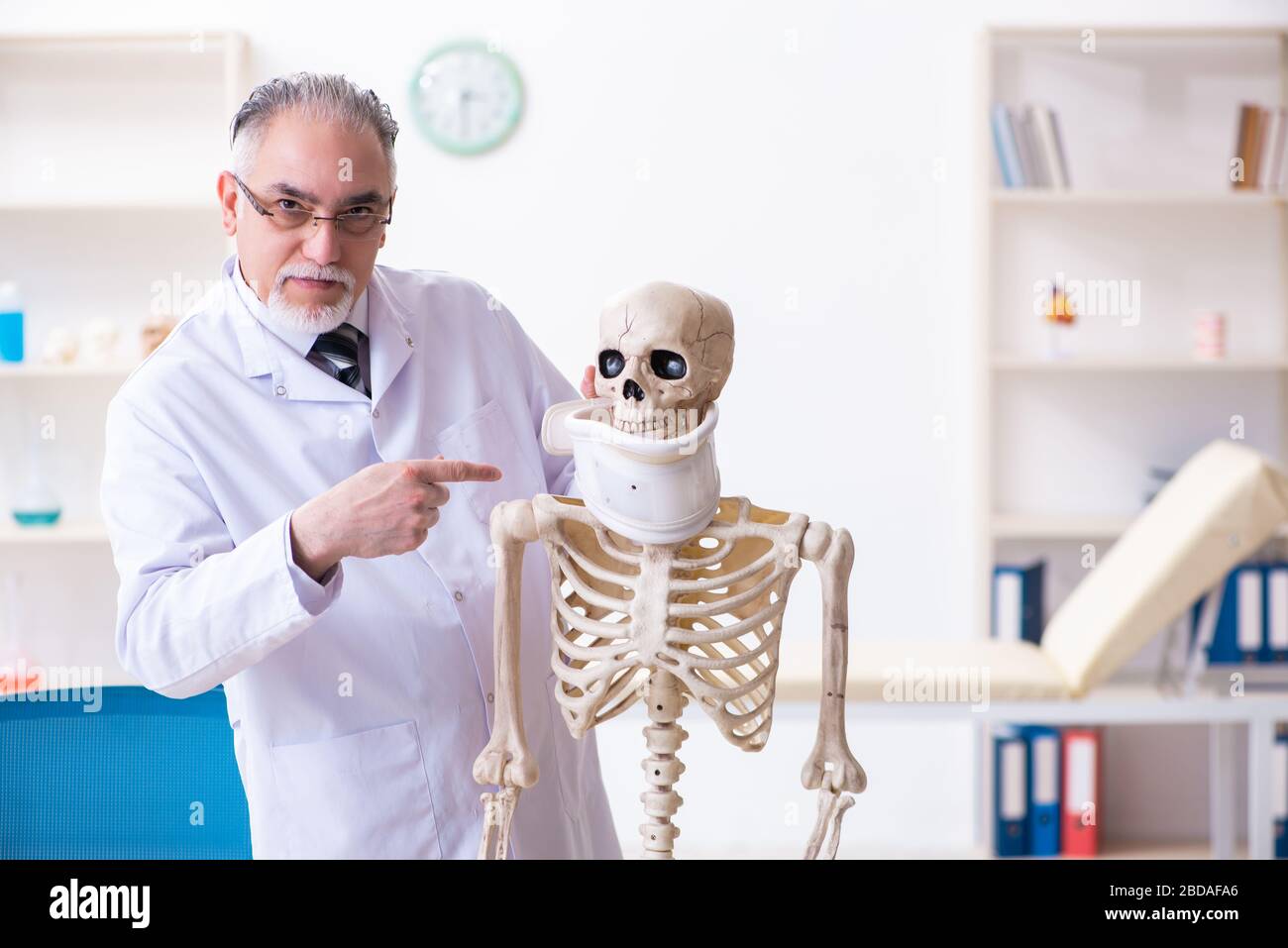 The aged male doctor with skeleton Stock Photo - Alamy